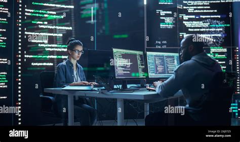 Portrait Of Two Programmers Working In A Monitoring Control Room