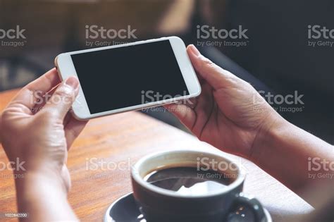손에 들고 사용 하 고 흰색 휴대폰 빈 검은 화면이 가로로 나무 테이블에 커피 컵 보고의 이랑 이미지 공란에 대한 스톡 사진 및 기타 이미지 Istock