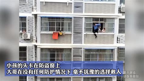 小孩的头卡在防盗窗上大哥在没有任何防护情况下毫不犹豫救人