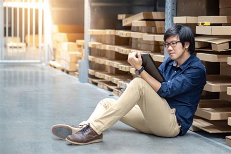 아시아 젊은이 디지털 태블릿을 사용 하 여 창 고 선반에 골 판지 상자에 제품의 재고 조사를 하 고 실제 재고 카운트 개념