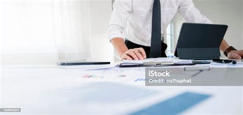 현대 사무실의 책상에서 사업 계획을 작성하는 젊은 사업가 계획 그래프 차트 와 디지털 태블릿을 사용하여 투자 비즈니스 전략 및 마케팅을 분석합니다 노트북에 대한 스톡 사진