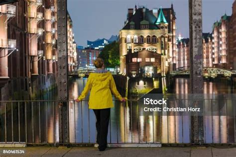 밤에 조명 오래 된 창 고 지구 슈파이셔슈타트 함부르크 독일에서 다리에 노란 우비 서에서 젊은 여자의 긴 노출 슈파이혀슈타트에 대한 스톡 사진 및 기타 이미지 Istock