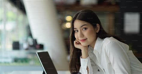 젊은 아름다운 사업가가 뺨에 손을 대고 웃고 직장에서 종이컵을 들고 있는 측면 모습 사진 Unsplash의 태국 이미지