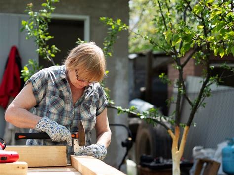 Premium Photo Senior Caucasian Woman Assembles A Wooden Frame Of