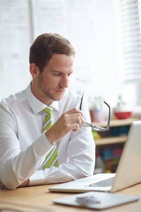 Thinking Glasses And Businessman On Laptop In Office For Brainstorming