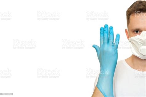 흰색 배경에 흰색 보호 마스크라텍스 보호 장갑에 젊은 외과 의사 의료 용 장갑과 보호 얼굴 마스크를 착용한 남자 코로나바이러스