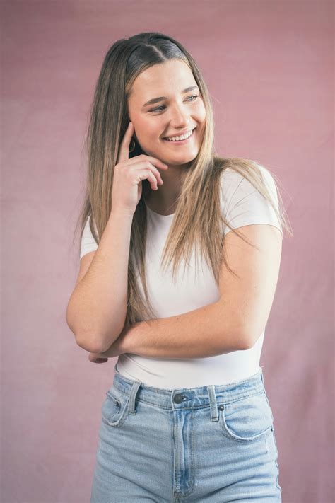 검은색 터틀넥을 입고 야외에서 웃는 여자 · 무료 스톡 사진