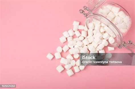 유리 그릇에 분홍색 배경에 마시멜로 하얀 마시멜로 플랫 레이 간식을위한 과자와 스낵 씹는 사탕 클로즈업 공간을 복사합니다 텍스트를위한 장소 겨울 음식 개념 개체 그룹에 대한