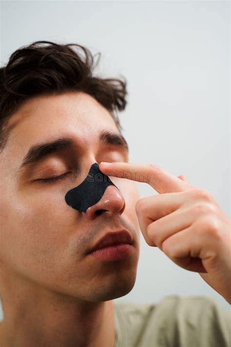 Man With Charcoal Nose Strip For Pores Cleaning Young Guy Applying