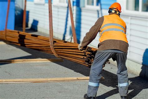 Slinger는 건설 현장의 스택에 얇은 금속 파이프를 쌓습니다 클로즈업 실제 작업 흐름 장비 공급업체의 생산 배경 건설을