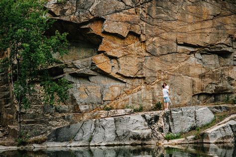 남자는 바위의 배경에 포옹 여자 손에 집어 들었다 오래 된 산업 화강암 채 석 장의 풍경입니다 캐년 텍스트와 디자인을 위한 장소 호수 강 전체 길이 2명에 대한 스톡 사진