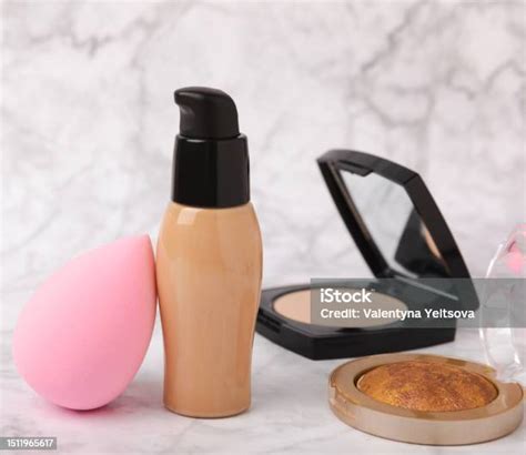 뷰티 블렌더와 파운데이션 크림은 흰색 대리석 배경에 있다 메이크업 화장품 스폰지 메이크업 제품 아름다움 개념입니다 텍스트를 위한 위치입니다 복사를 위한 공간입니다 플랫 레이