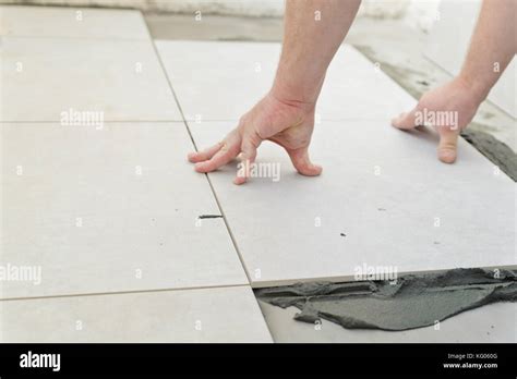 Laying Ceramic Tiles Troweling Mortar Onto A Concrete Floor In