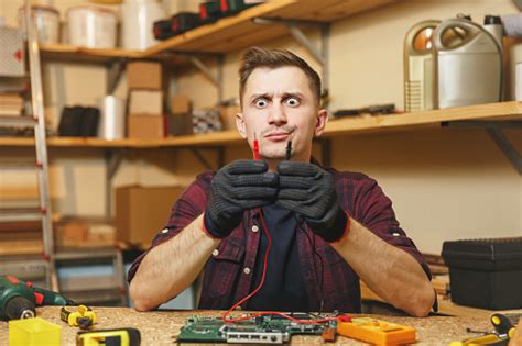 전기에 대 한 멀티 미터입니다 미친 적극적인 박쥐 미친 재미 젊은 남자 격자 무늬 셔츠 디지털 전자 엔지니어 복구 컴퓨터를 납땜 도구 나무 테이블에서 워크숍에서 Pc 마더