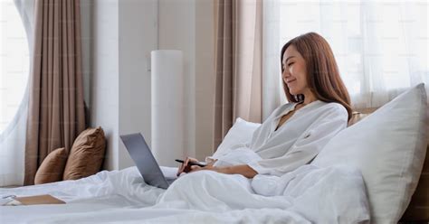 집에서 침대에 누워 노트북 컴퓨터를 사용하고 작업하는 아름다운 젊은 아시아 여성 사진 Unsplash의 랩톱 이미지