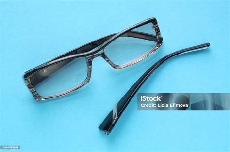 파란색 배경에 다리가 손상된 오래된 깨진 안경 시력이 좋지 않습니다 재사용 및 수리 개념 건강에 대한 생각 고장 광학 안경 시력 교정 안경 파손 클로즈업 플랫 레이 0명에