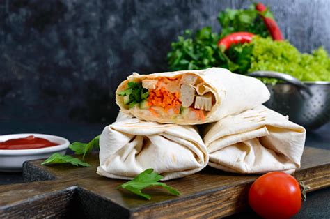 검은 배경에 맛 있는 샤 왈 마 샌드위치 부리토에 구운 닭고기와 채소 채소로 감싼 답니다 파히타 피타 빵 전통적인 중동 전채 요리 건강 한 음식 멕시코 요리를 제공 합니다