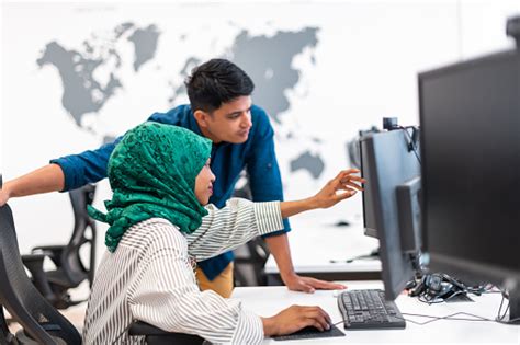 다민족 스타트업 비즈니스 팀 인 아라비아 여성이 노트북과 데스크톱 컴퓨터에서 작업하면서 현대 오픈 플랜 사무실 인테리어 브레인 스토밍에서 회의에 히잡을 착용하고 있습니다