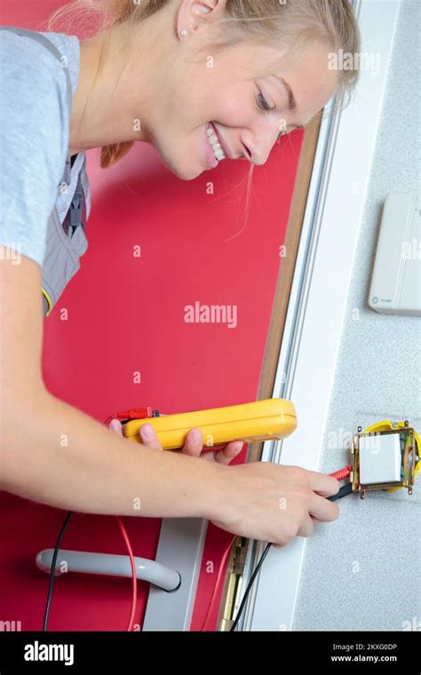 Happy Female Electrician Testing A Wall Socket Stock Photo Alamy