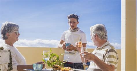 할아버지 성인 성인 및 십대 손자는 테라스에서 음식과 음료와 함께 야외 활동을 즐깁니다 바다와 도시 전망 휴가 화창한 날 좋은 날씨 개념과 배경 함께 행복한 사람들
