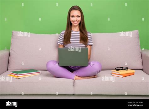 Portrait Of Attractive Cheery Girl Sitting On Divan Using Laptop Watching Video Isolated Over