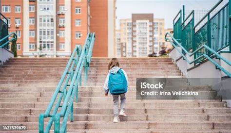 초등학교 초등학교로 돌아 가기 큰 배낭을 가진 어린 소녀는 가을 아침에 혼자 일학년 늦게까지 서둘러 간다 교육 아이들의 미래 계단 계단에서 행복하고 불행한 학생 아이 4 5