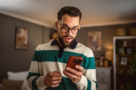 성인 남자의 초상화는 집에서 휴대 전화를 서서 사용합니다 30 34세에 대한 스톡 사진 및 기타 이미지 30 34세 거실 고름 Istock