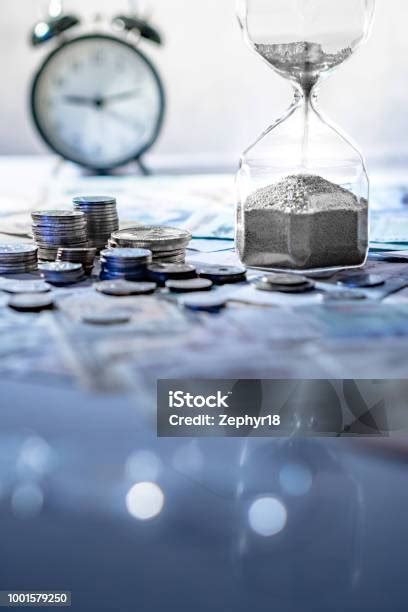 국제 통화의 동전 지폐와 테이블에 모래 시계 모양을 통해 실행 하는 은색 모래 시간을 투자 하 고 은퇴 절약입니다 비즈니스 마감 개념에 대 한 긴급 카운트 다운 타이머