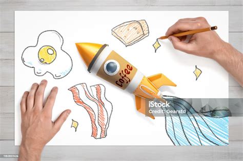 빵을 그리는 손의 위에서 중앙에 커피 컵으로 만든 장난감 로켓과 함께 흰 종이에 계란과 베이컨을 볼 수 있습니다 로켓에 대한 스톡 사진 및 기타 이미지 Istock