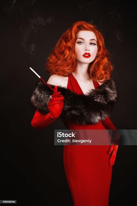 빨간 드레스에 긴 장갑 검은 배경에 연기 곱슬 머리와 빨간 머리 여자 여자는 옷을 입고 자연 모피와 레트로 스타일과 하얀 치아와 피스 손 Film Festival에 대한