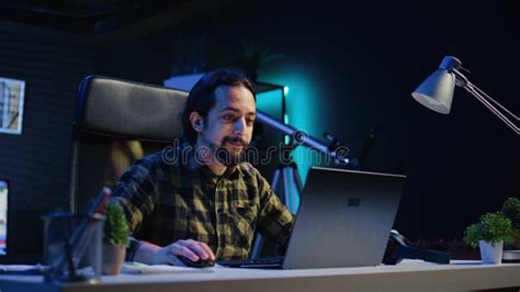 Freelancer In Neon Lit Home Office Sitting At Desk And Typing On Laptop Stock Footage Video Of
