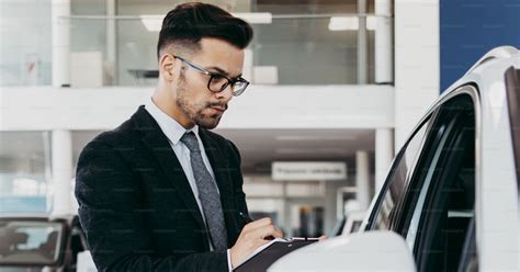 구매자가 오기 전에 마지막으로 쇼룸 및 품질 관리 검사에서 일하는 자동차 판매자 사진 Unsplash의 자동차 대리점 이미지