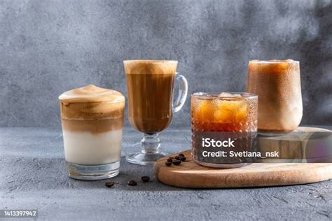 에스프레소 토닉 유리에 에스프레소와 강장제를 곁들인 차가운 음료 크림을 붓고 커피 원두를 얹은 키 큰 유리에 아이스 커피 어두운 테이블에 다양한 종류의 커피 음료가 놓여
