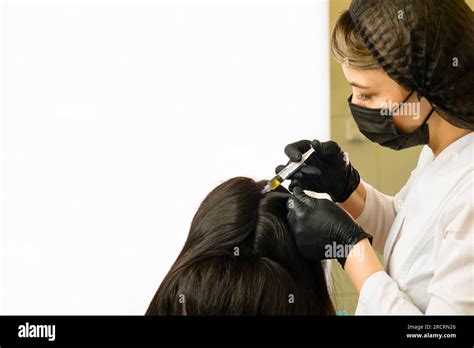 Сosmetologist uses thin needle to inject Platelet Rich Plasma in scalp PRP therapy and plasma