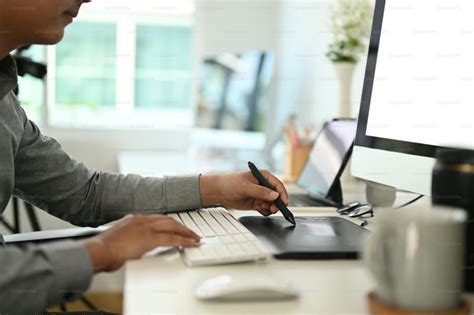 사진 촬영 후 그래픽 태블릿과 스타일러스 펜을 사용하여 사진을 편집하는 사진작가의 자른 사진 사진 Unsplash의 유행 이미지