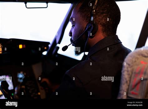 African American Copilot Flying Airplane In Cockpit With Captain Using Lever And Power Buttons