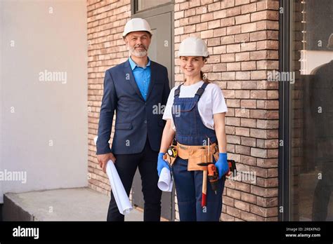 Male Architect With Layouts And Forewoman Discussing Next Step Of Building Stock Photo Alamy