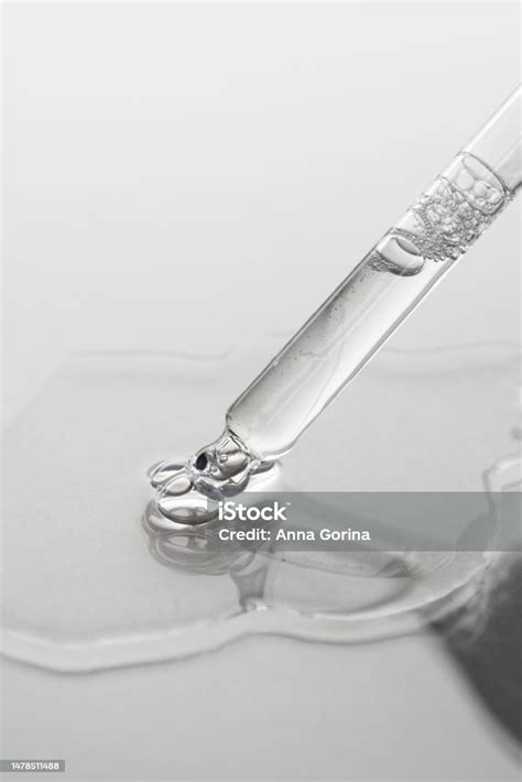 회색 배경에 유리 피펫에서 거품이 쏟아지는 혈청 또는 오일의 매크로 드롭 화장품 광고 혁신과 기술 개념 스킨 케어 트리트먼트