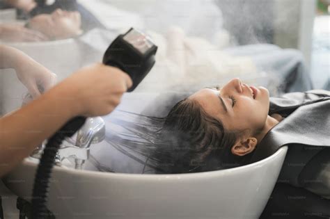 미용실 머리 장식 샴푸 헤어 케어로 여성 머리 치료 소녀 머리 장식 패션 개념에서 여성 고객과 함께 머리를 깨끗하게 씻는 전문 미용사 사진 Unsplash의 헤어