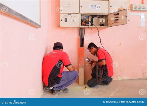 Technician Wiring Cable In Front Of Electrical Panel For Control And Distribute Electrical Power