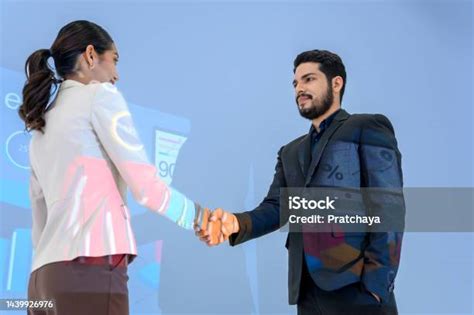 비즈니스 프리젠 테이션을 마친 후 악수하는 비즈니스 파트너 빅 스크린의 인포그래픽 애니메이션 앞에 서 있는 사업가 남녀 개념을 성공시키는 사업 2명에 대한 스톡 사진 및