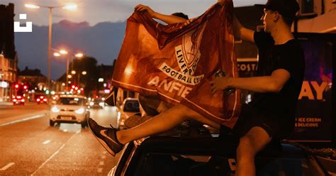 해질녘 자동차 후드에 앉아 있는 검은색 탱크탑을 입은 남자 사진 Unsplash의 무료 영국 이미지