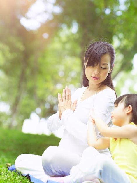 Premium Photo Pregnant Mother And Daughter Exercising Together At Park