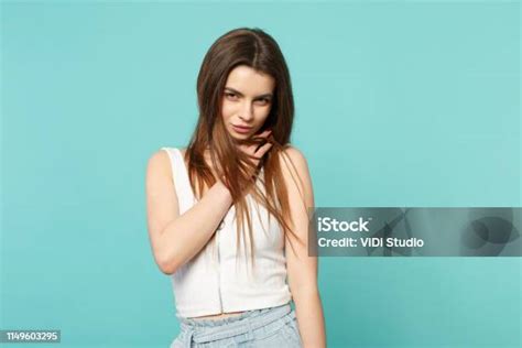 스튜디오에서 파란색 청록색 벽 배경에 고립 된 빛 캐주얼 옷을 찾고 매력적인 멋진 젊은 여자의 초상화 사람들은 진심으로 감정