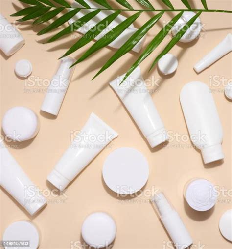 베이지색 배경에 흰색 플라스틱 튜브 항아리 및 Gypsophila 가지 화장품 크림 및 젤용 용기 광고 및 브랜드 프로모션 상위