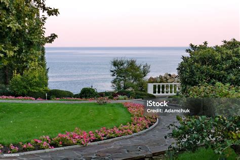 공원에서 경로 녹색 잔디밭 한쪽에 꽃 침대와는 다른 바다의 아름 다운 보기를 포함 하는 접시의 큰 다양 한 포장 0명에 대한