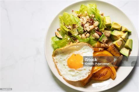 으깬 견과류 아보카도 계란 구운 피망 호박을 접시에 곁들인 건강한 그린 샐러드 흰색 테이블 배경에 격리된 상위 뷰 0명에 대한