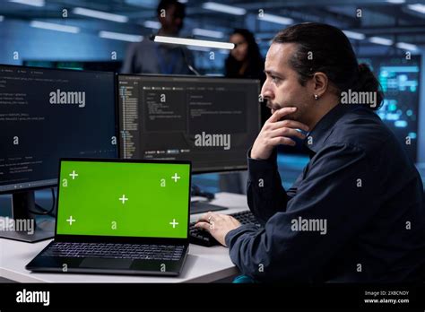 Man In Server Hub Uses Green Screen Laptop To Find Firewall