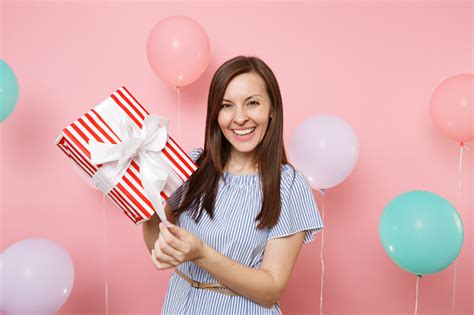 선물 다채로운 공기 풍선 파스텔 핑크 배경에 빨간색 상자에 파란색 드레스 풀 나비에 꽤 웃는 여자의 초상화 생일 휴가 파티 사람들이 진심으 감정 개념 14에 대한 스톡 사진