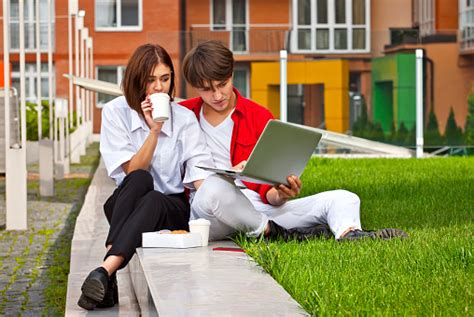 소년과 소녀는 함께 야외에서 점심을 먹는다 랩톱 화면을 보고 커플 패스트 푸드와 길거리 음식의 개념 종이 용기와 일회용 컵의 음식 18 19세에 대한 스톡 사진 및 기타